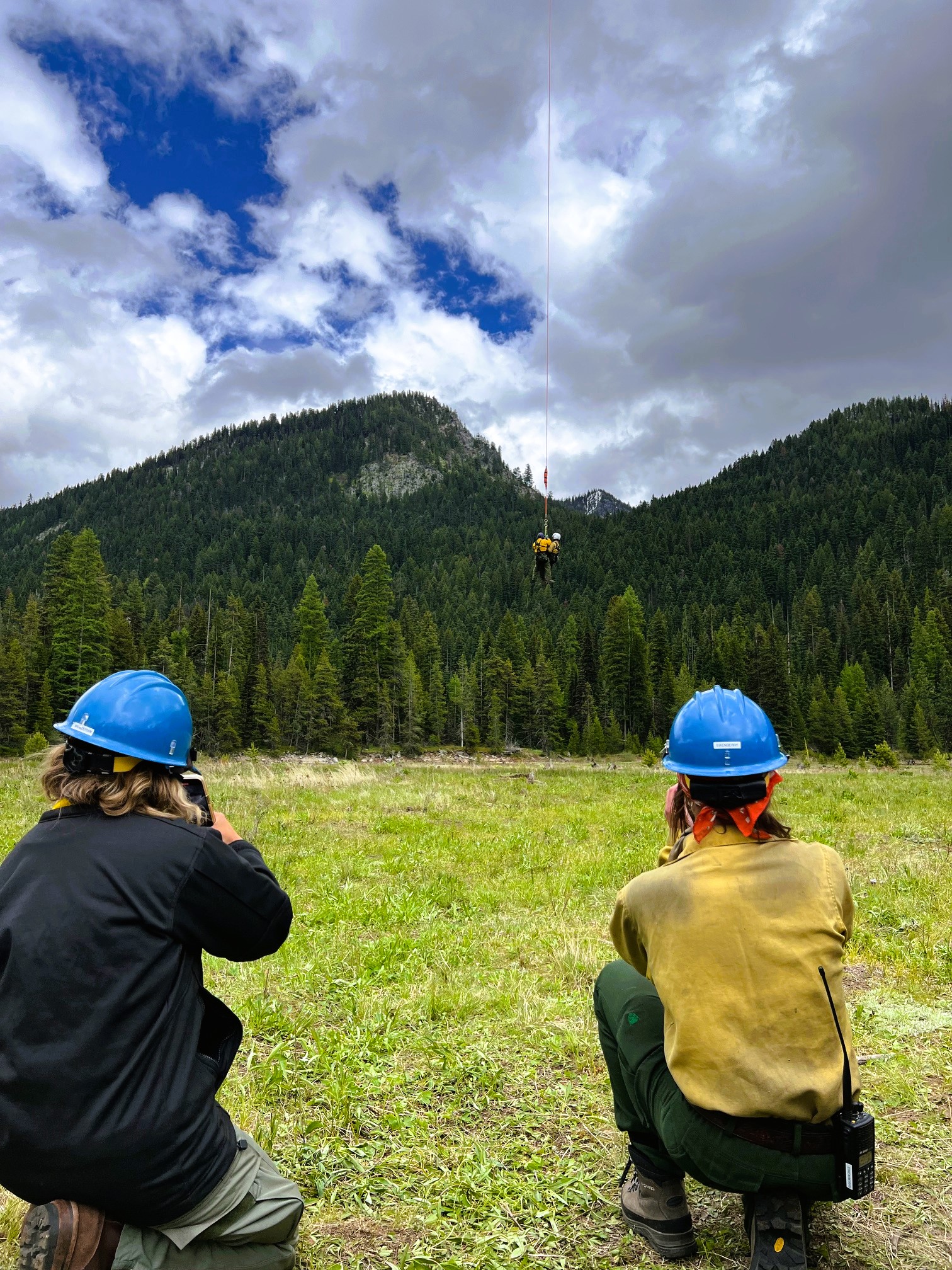 Helitack crewmembers observe their coworkers on a practice short-haul ...