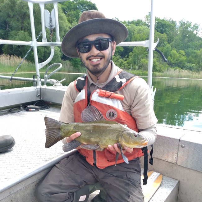 USFWS staff holding invasive tench | FWS.gov