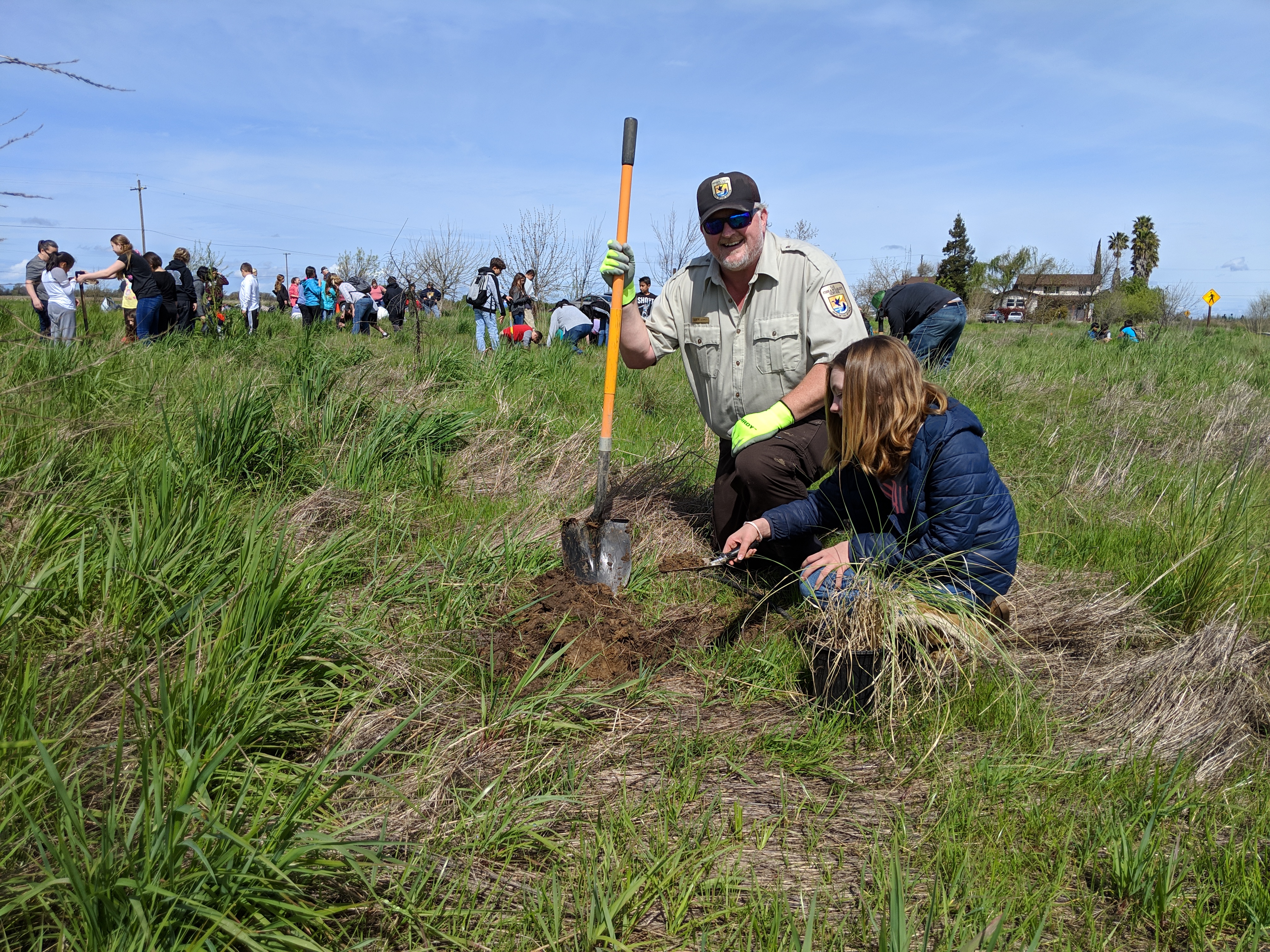 USFWS staff planting with school kids | FWS.gov