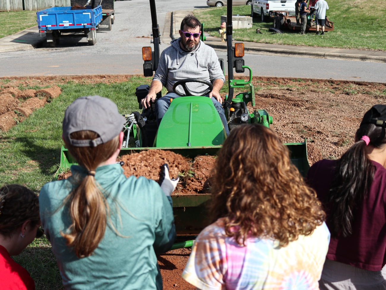 Volunteers load Eric Bradford's tractor with sod as a site is cleared ...